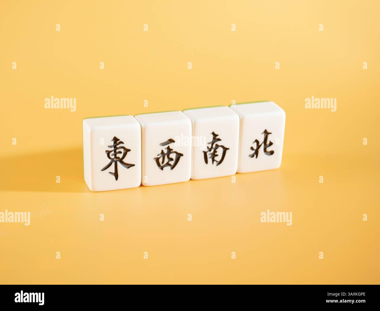 Four white mahjong tiles with Chinese characters, arranged on a bright ...