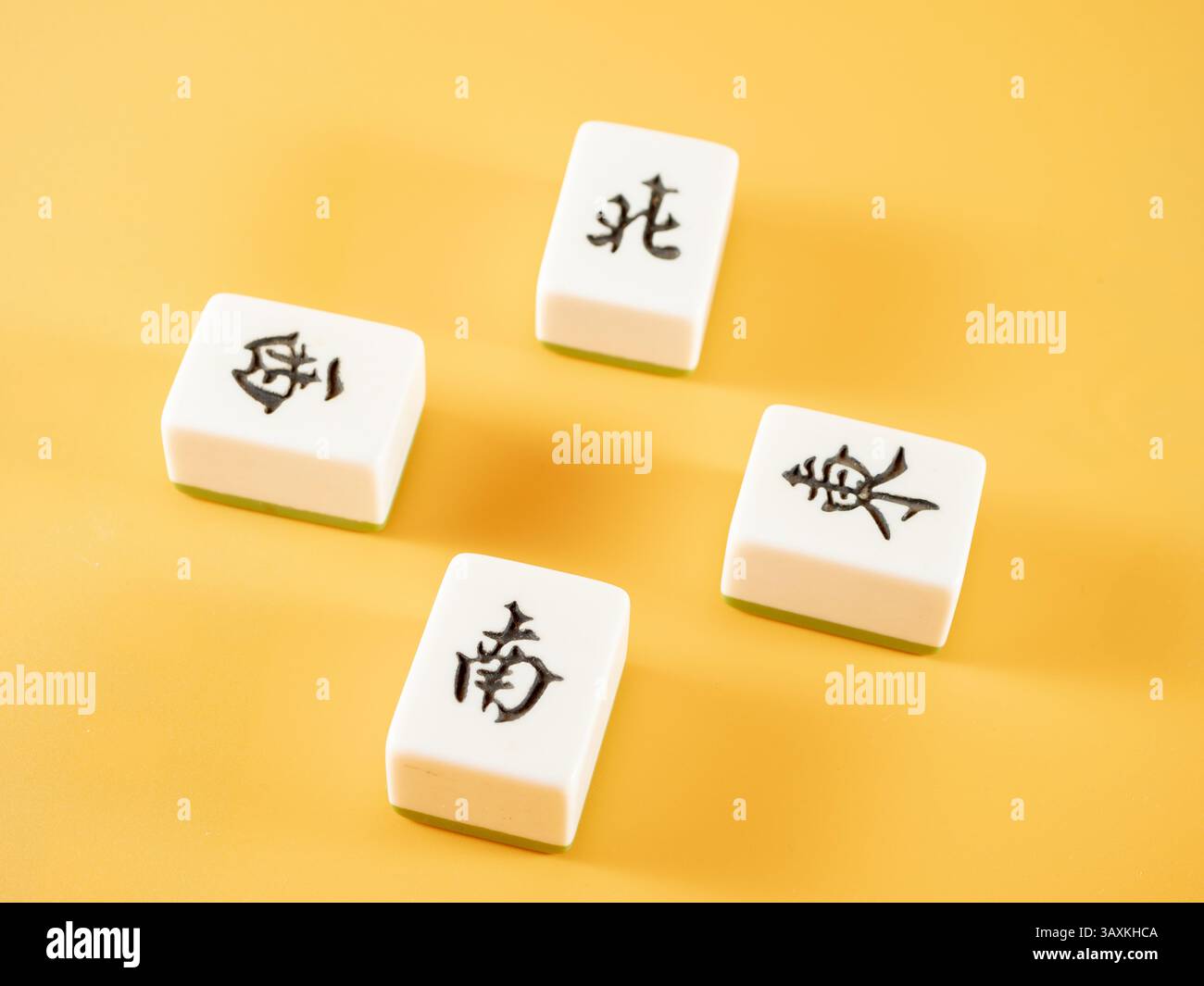 Four white mahjong tiles with Chinese characters, arranged on a bright ...