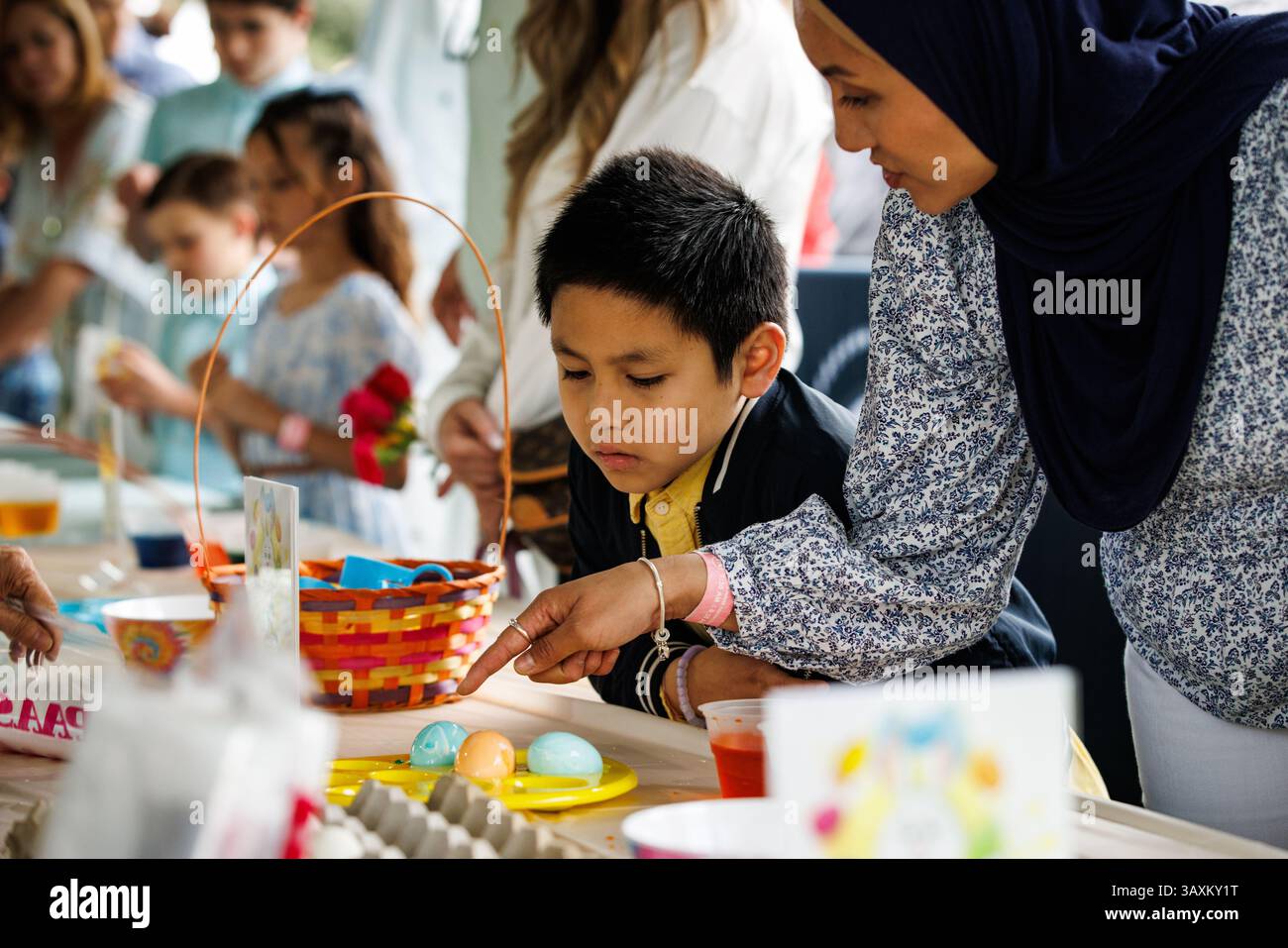 A mother and son dye colored eggs during the 2025 Easter Egg Roll on the South Lawn of the White ...
