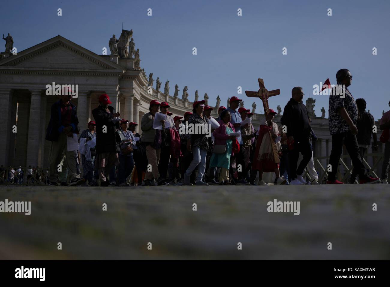 Pilgrims carrying a cross make their way to the Holy Door in St. Peter ...