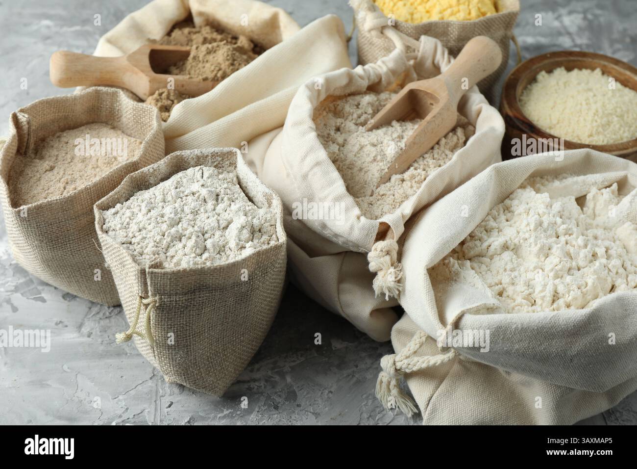 Different types of flour in bags on grey textured table, closeup Stock ...