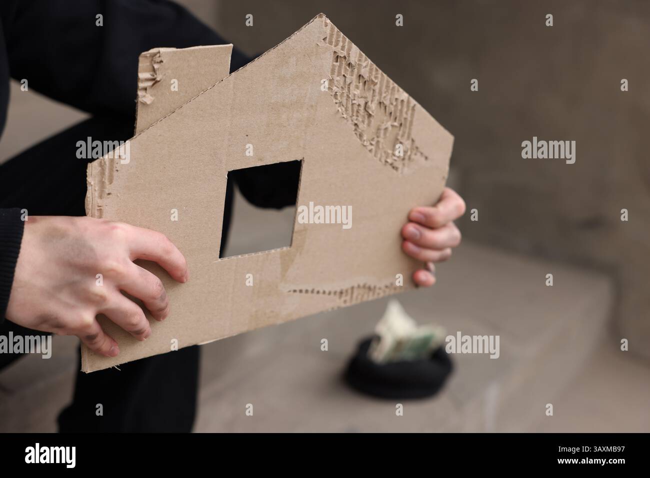 Homeless man with carton house figure outdoors, closeup Stock Photo - Alamy
