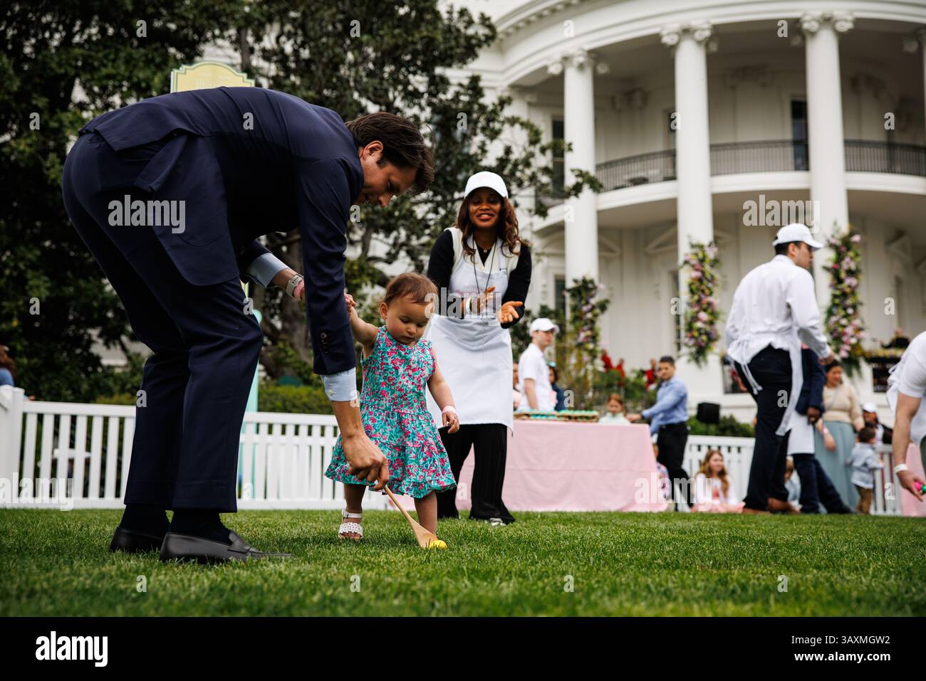 Guests compete race to push colored eggs across the grass during the 2025 Easter Egg Roll on the ...