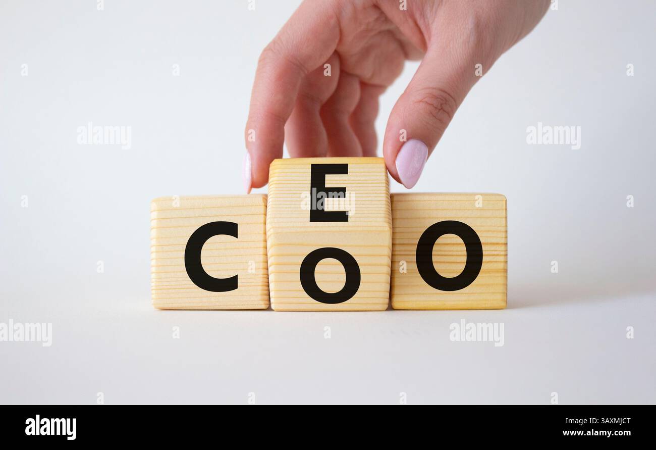 CEO and COO symbol. Businessman hand turns wooden cubes and changes ...