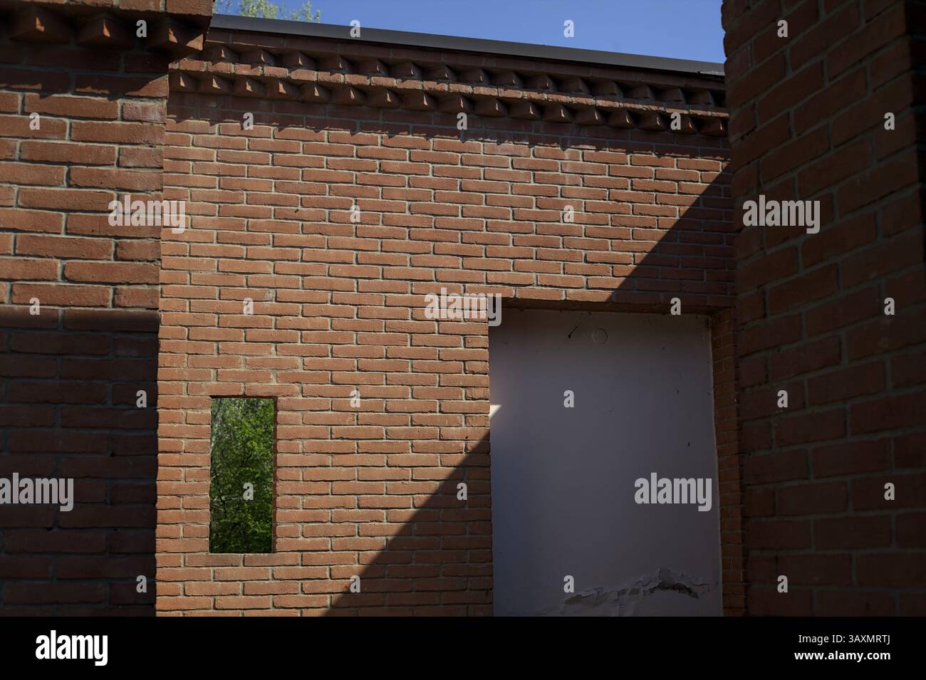 Detail of a brick structure in a park with an embrasure in a wall and a ...
