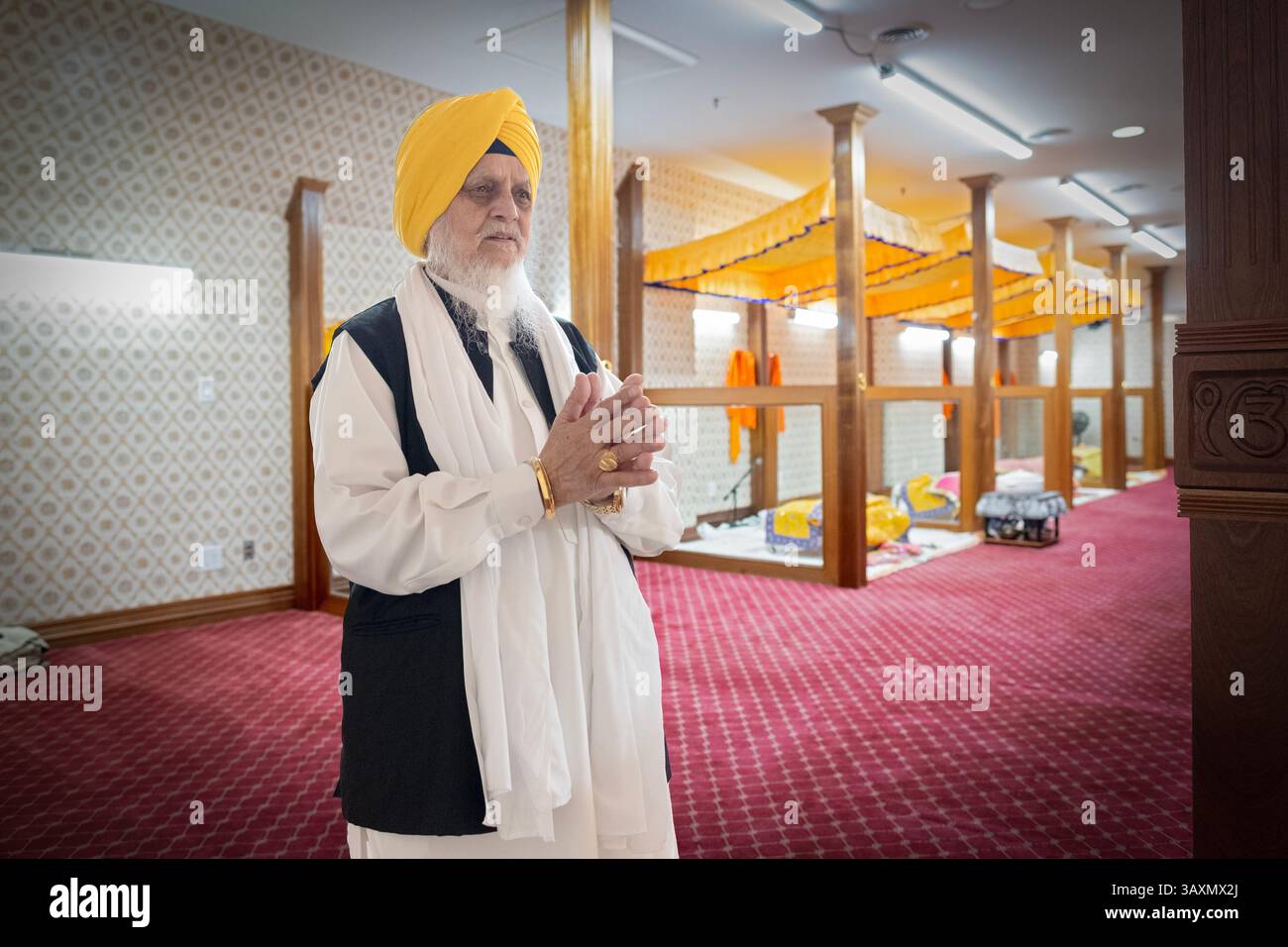 Posed portrait of a granthi priest in an area where holy books are read ...