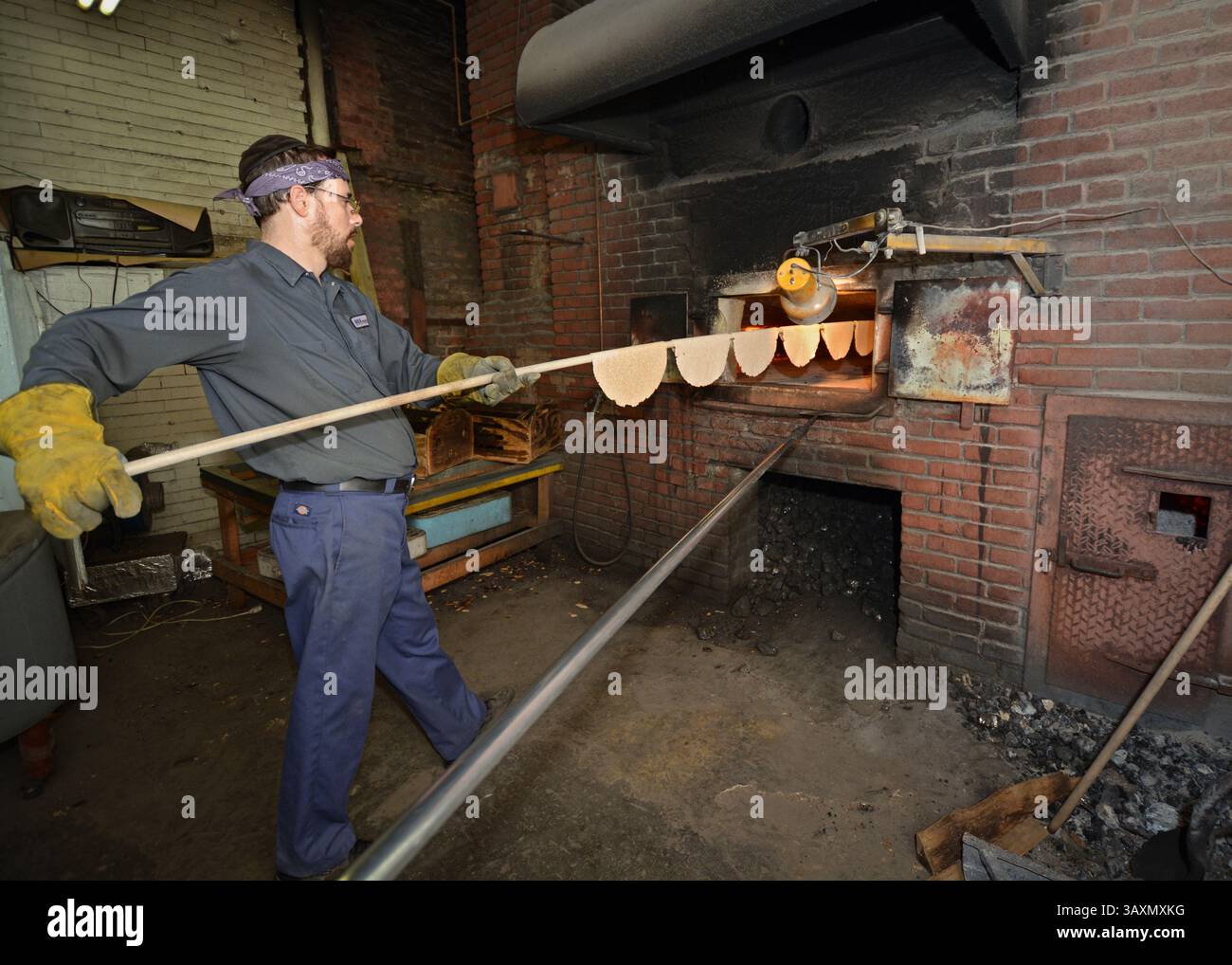 An orthodox Jewish man putting matzoh into the oven at the Borough Park ...