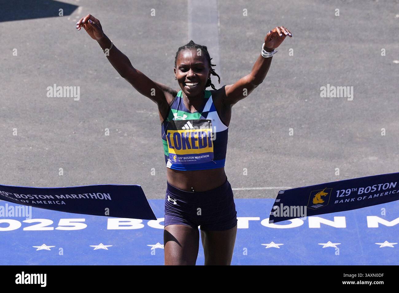 Sharon Lokedi, of Kenya, crosses the finish line to win the women's division of the Boston ...