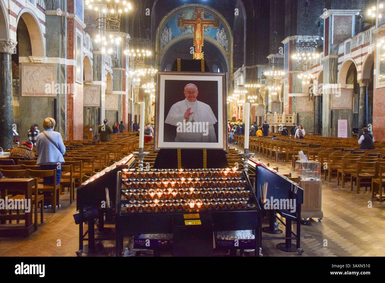 London, UK. 21st Apr, 2025. Candles are lit next to a picture of Pope ...