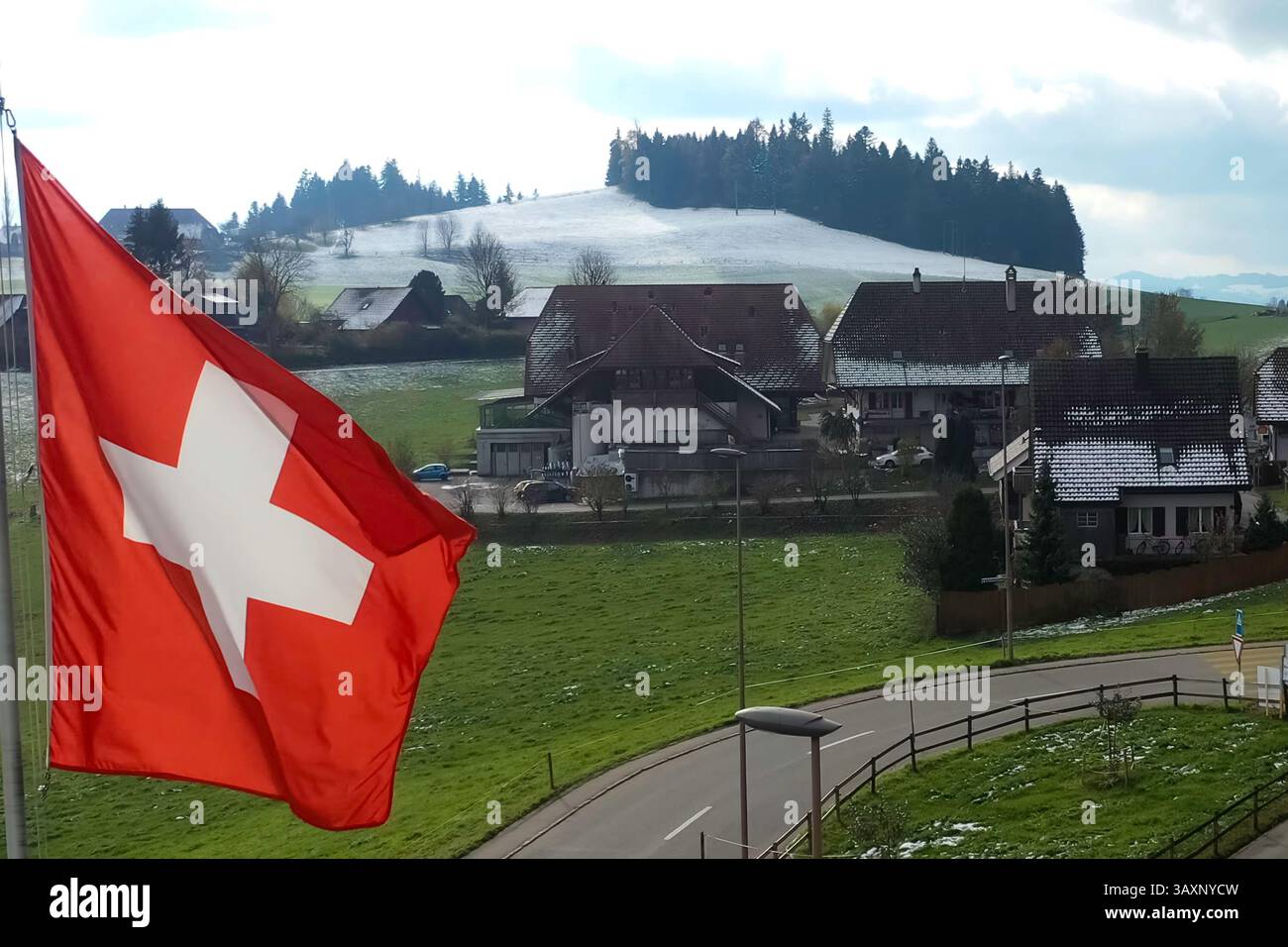 Swiss village, houses among the hills. Swiss flag against the ...