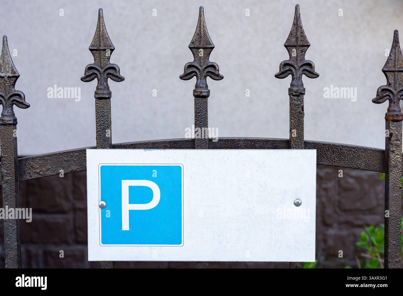 A parking sign displayed on a white panel attached to a decorative iron ...