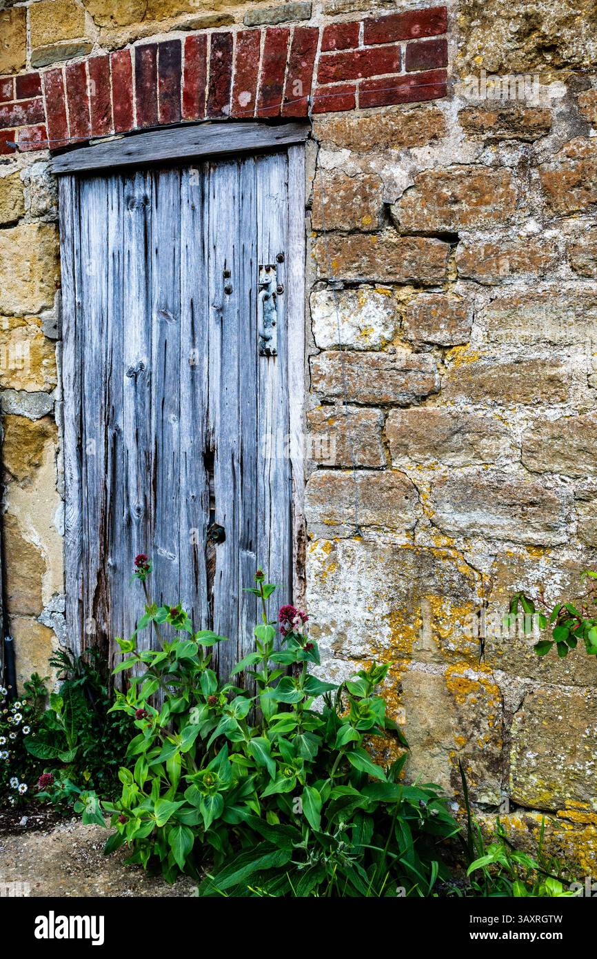 Old rustic wooden doorway set in golden stone wall, Symondsbury, Dorset ...