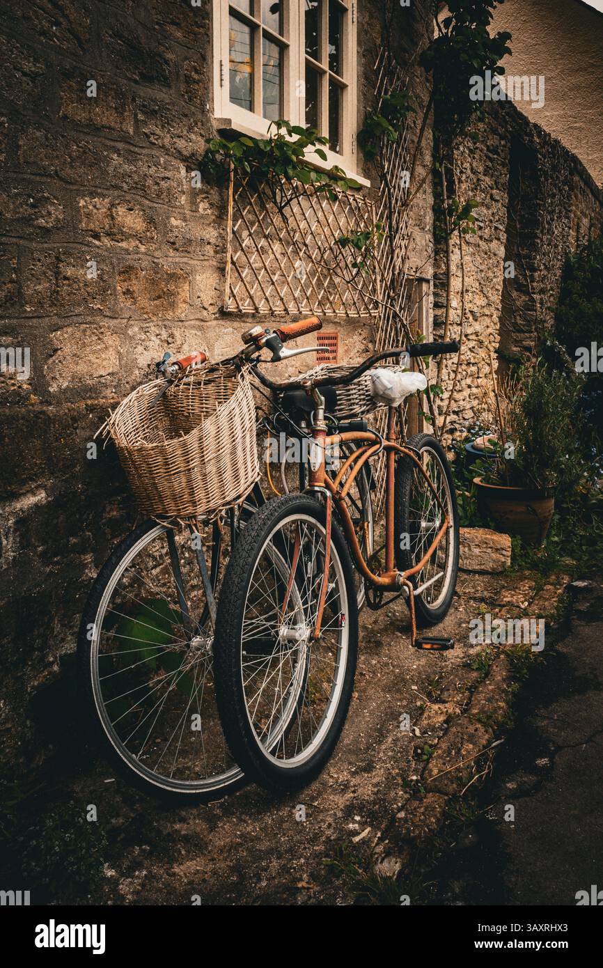 Vintage look. Bicycles, one with wicker pannier, parked outside a ...