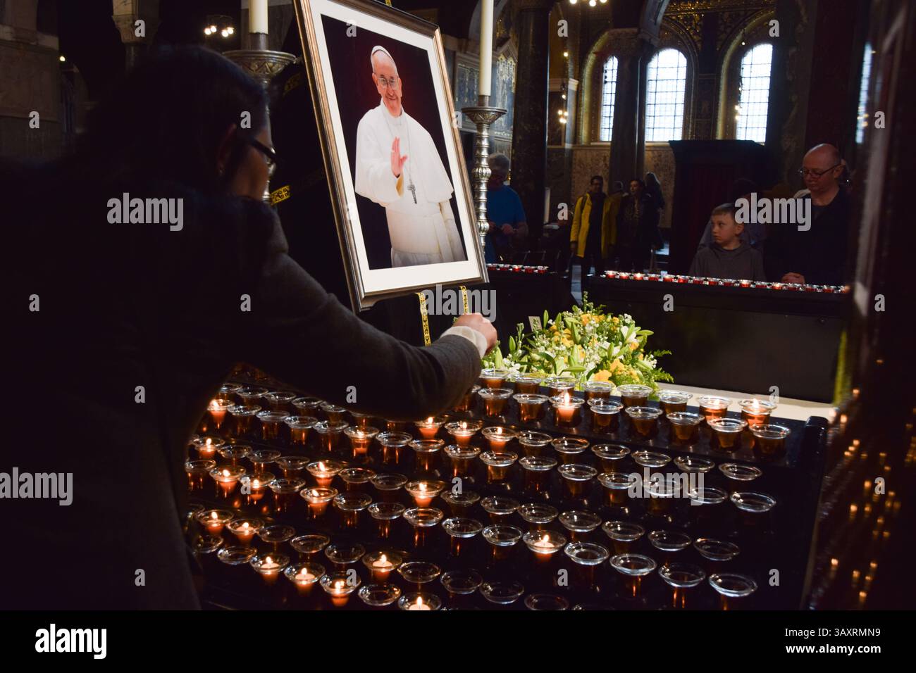 London, UK. 21st April 2025. People light candles next to a picture of ...