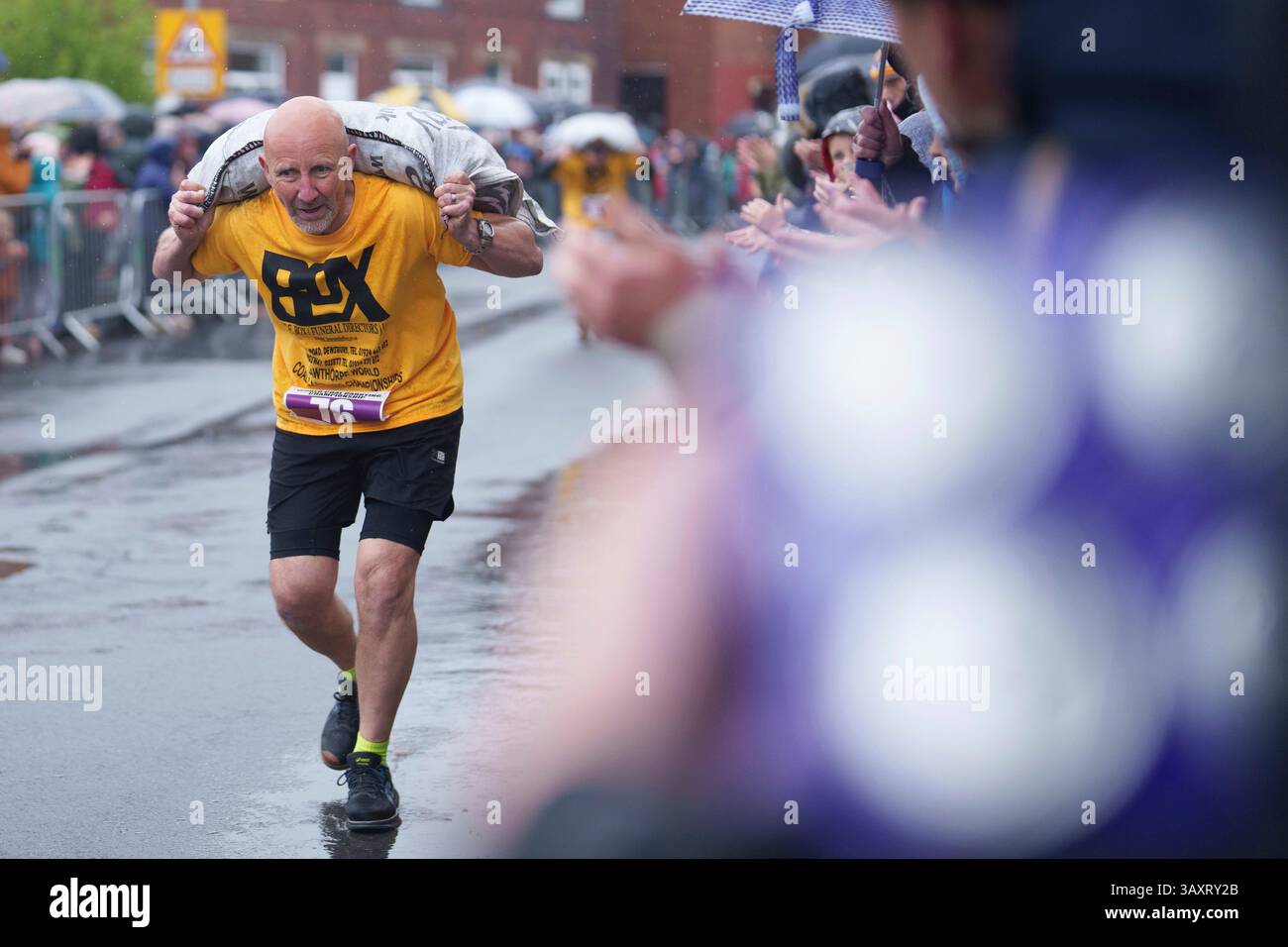 A contestant makes for the finish line carrying a 50kg sack of coal at ...