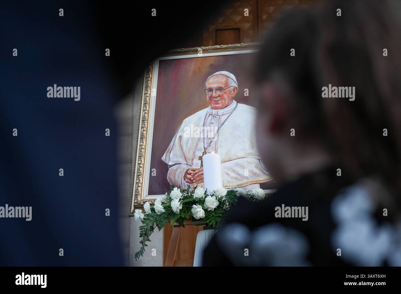 People light candles in front of a picture of Pope Francis in Kosovo ...
