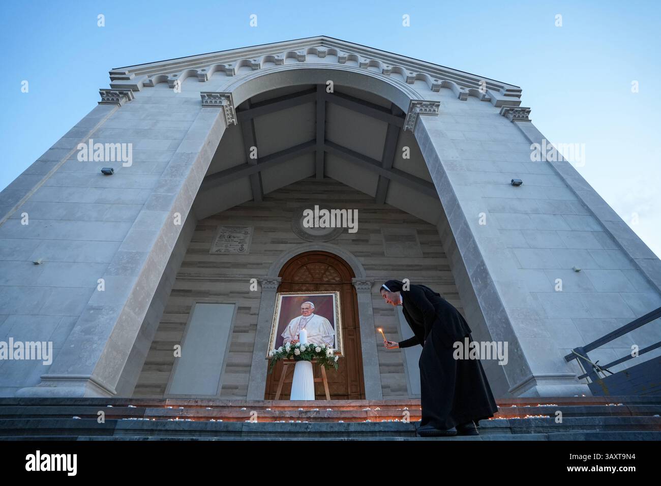 People light candles in front of a picture of Pope Francis in Kosovo A ...