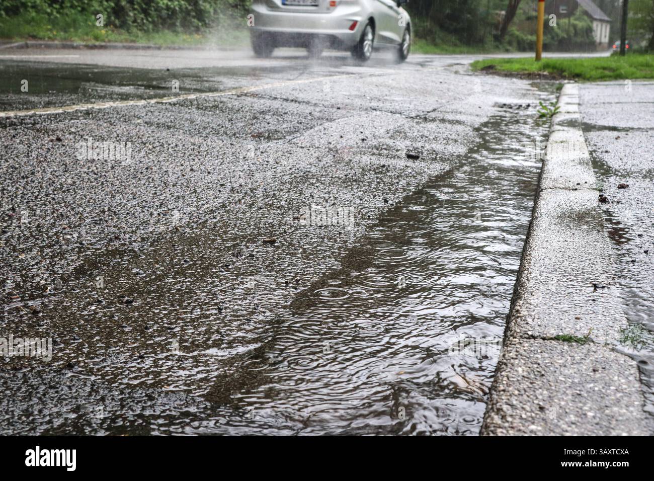 Kanalisation an Straßen Regenwasser fließt durch den Rinnstein bei ...