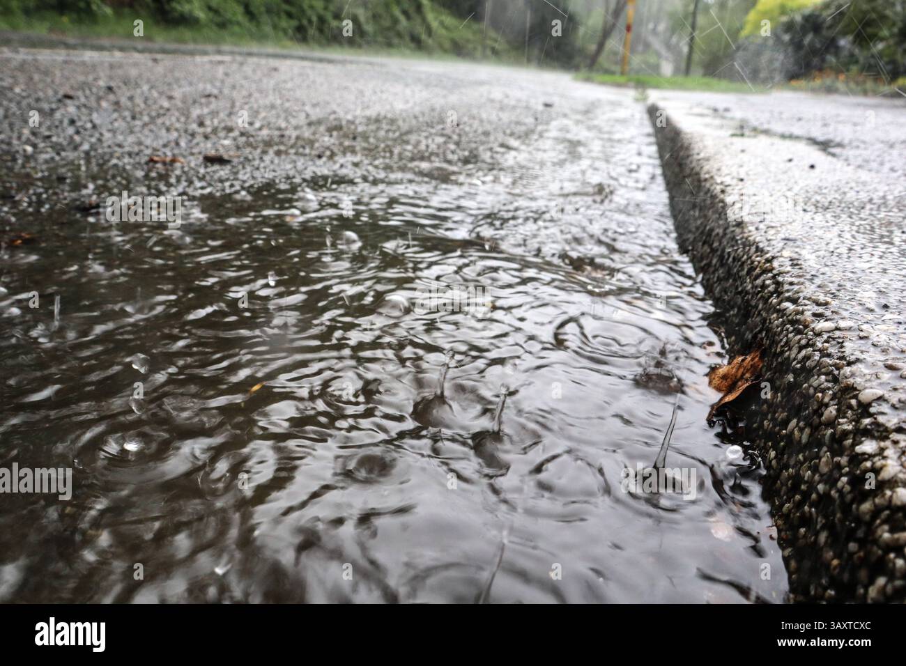 Kanalisation an Straßen Regenwasser fließt durch den Rinnstein bei ...