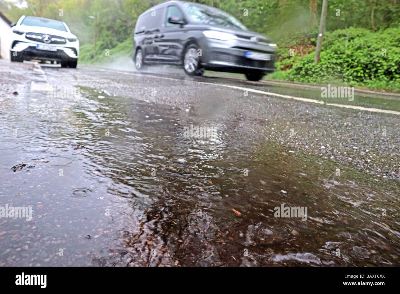 Kanalisation an Straßen Regenwasser fließt durch den Rinnstein bei ...