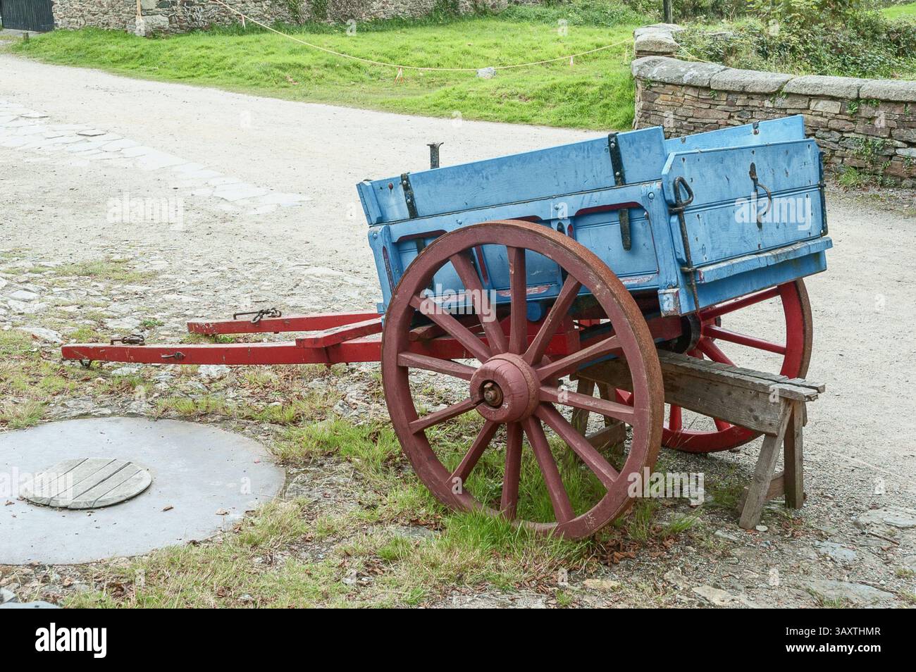 A blue and red 2-wheeled horse-drawn wooden cart at Morwellham Quay ...
