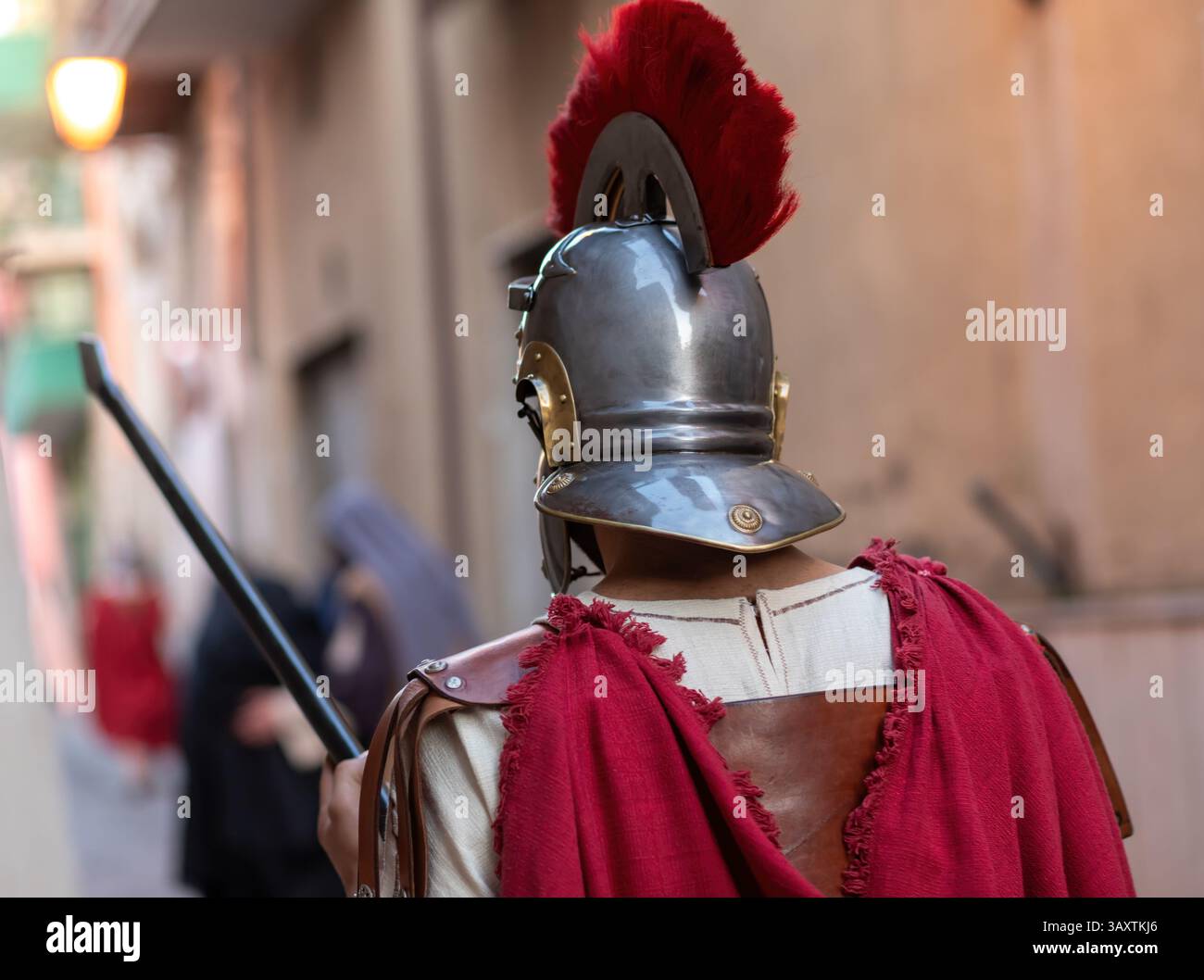 Roman centurion wearing a metal helmet with red plume, leather and ...