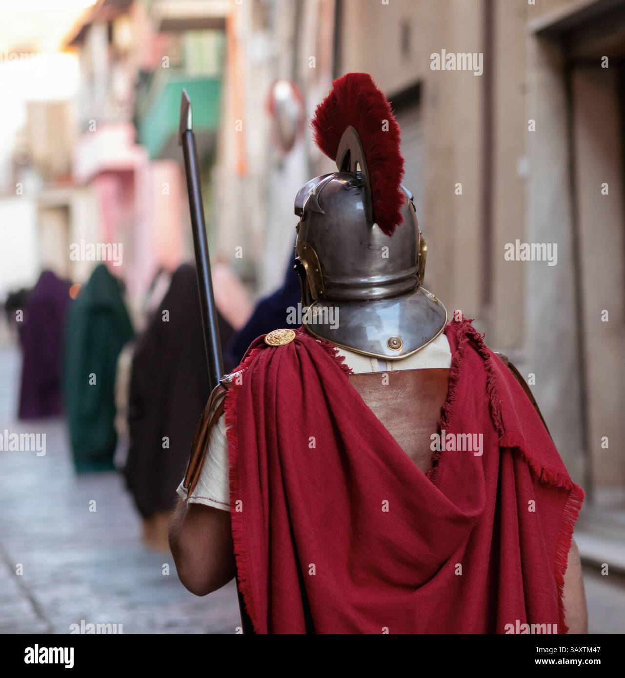 Roman centurion wearing a helmet with red plume and red cape, walking ...