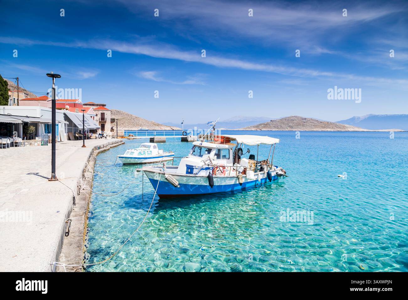 Various colouful fishing boats pictured in the turquoise waters around ...