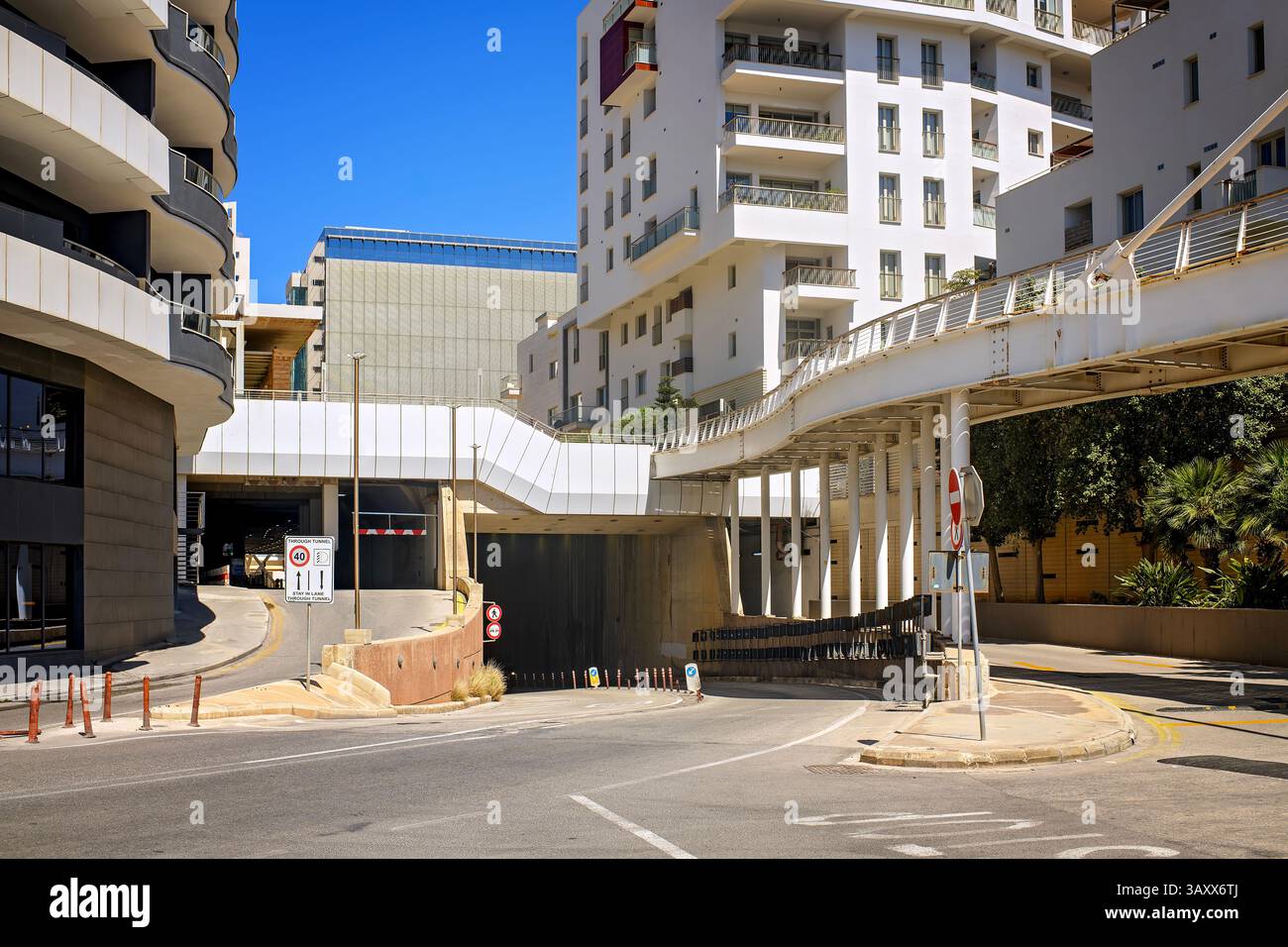 Modern urban intersection featuring a tunnel entrance, road splits with ...