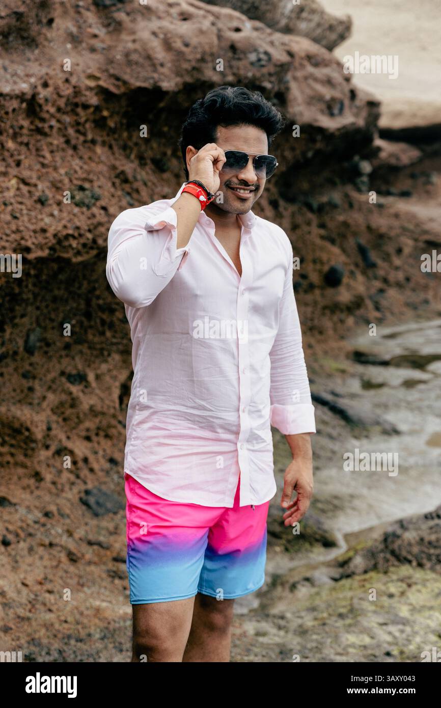 Confident Indian man smiling and touching his sunglasses, photo with ...