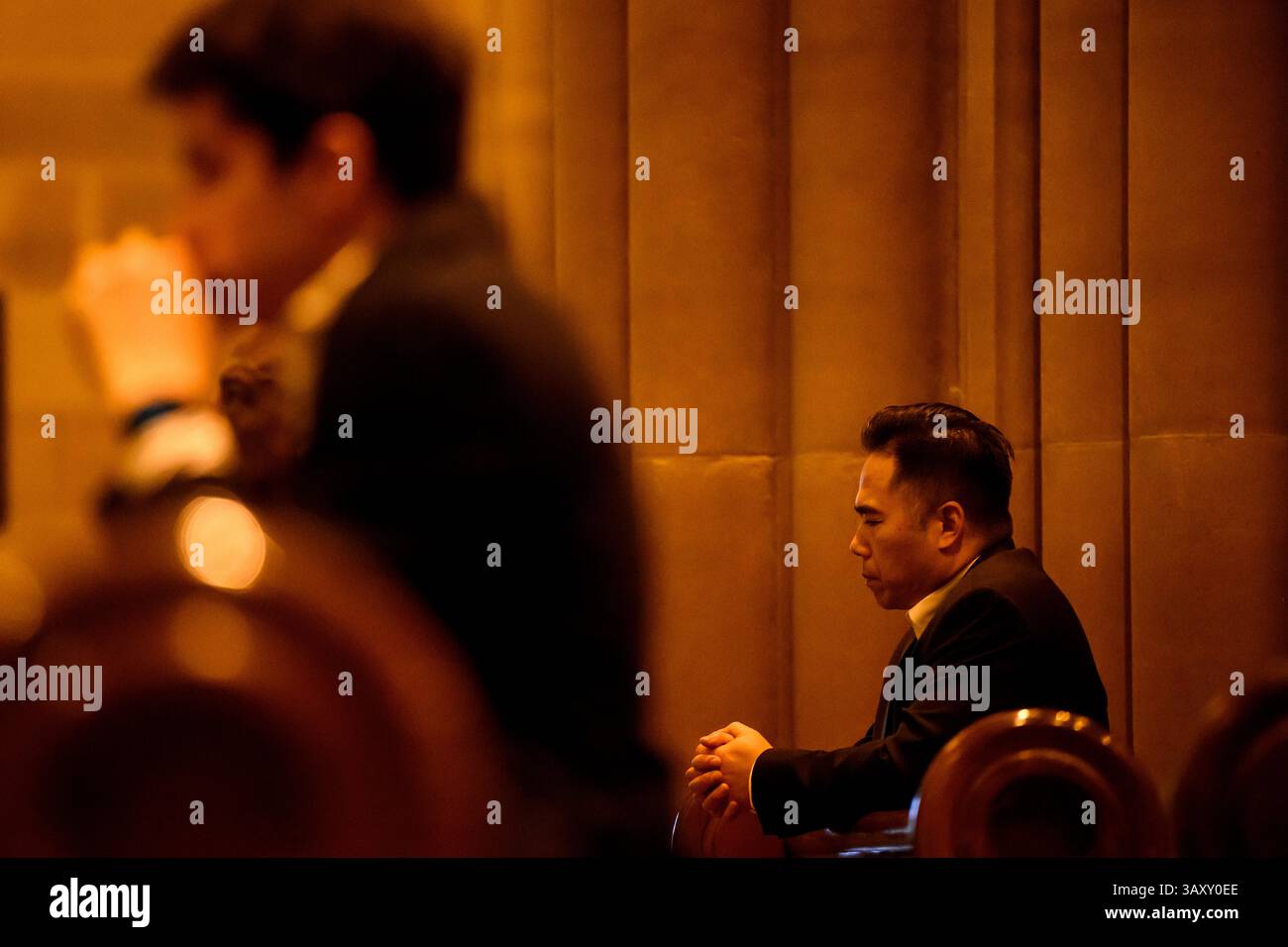 Members of the congregation pray during a service mourning the death of ...