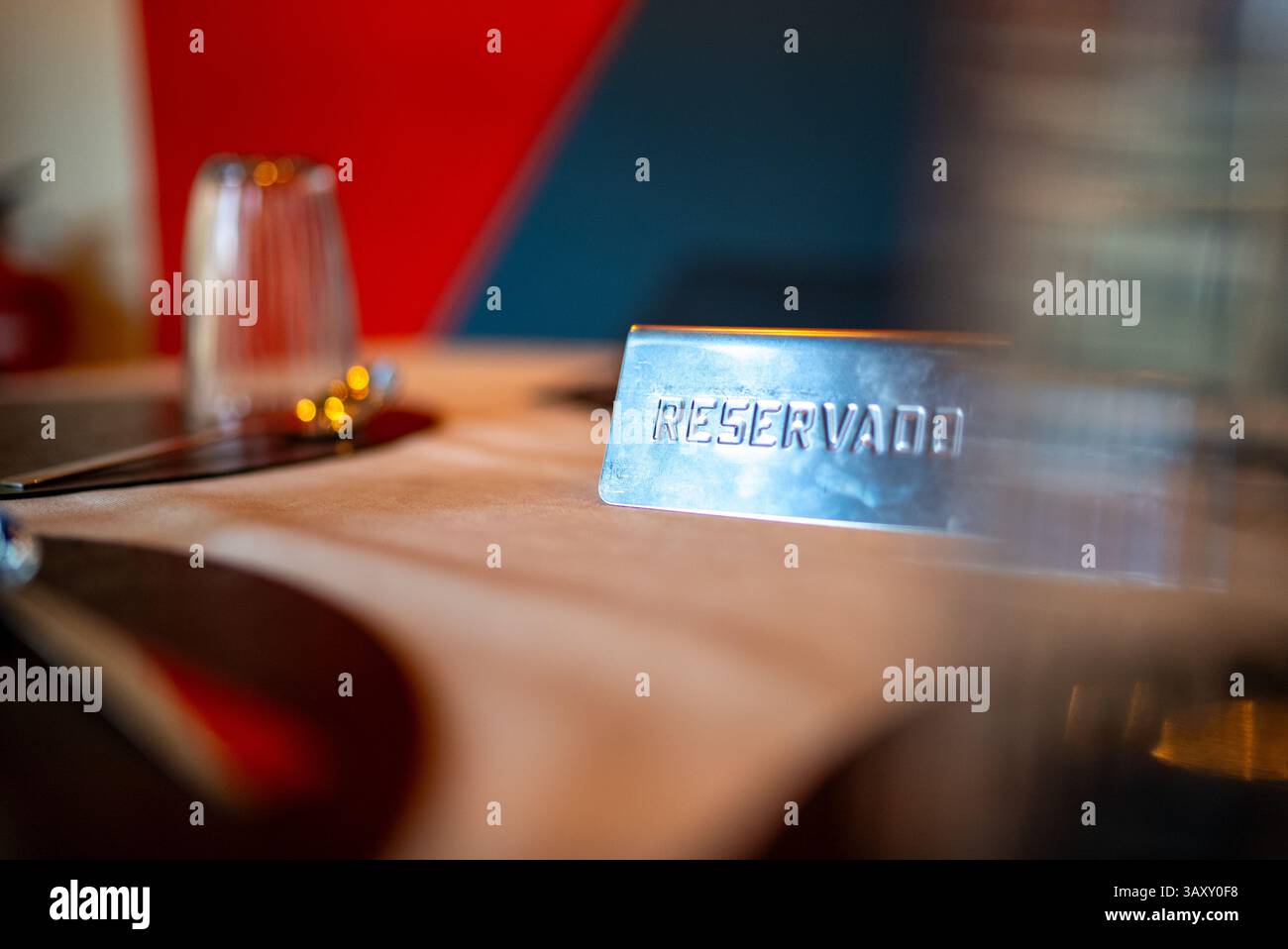 Reserved metal sign marking restaurant table, place settings including ...