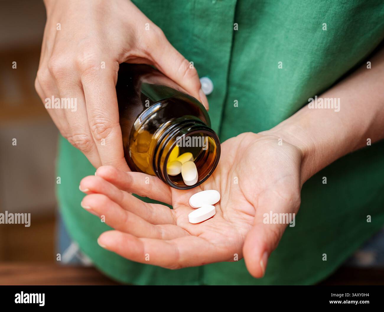 Woman pouring pills from bottle into her hand Stock Photo - Alamy