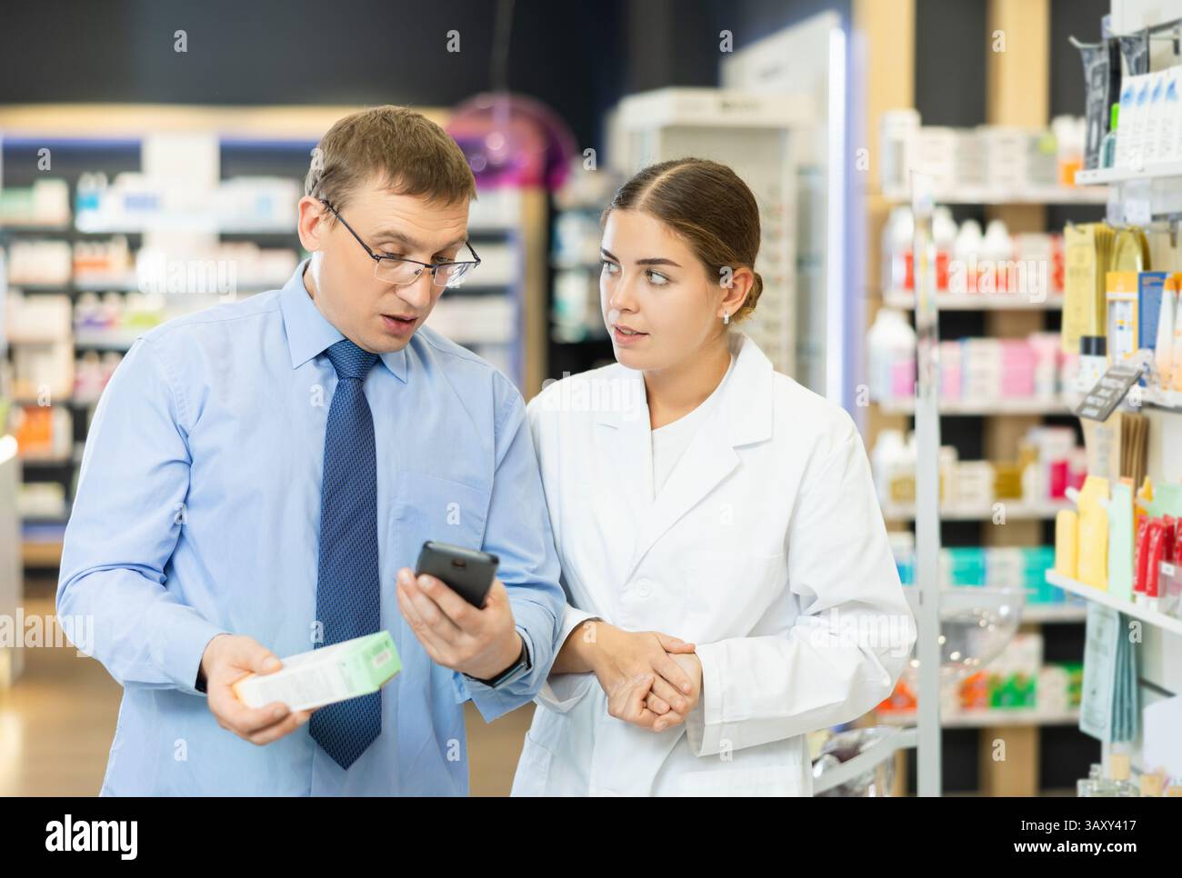 Male buyer together with female pharmacist scans QR code on medicine ...