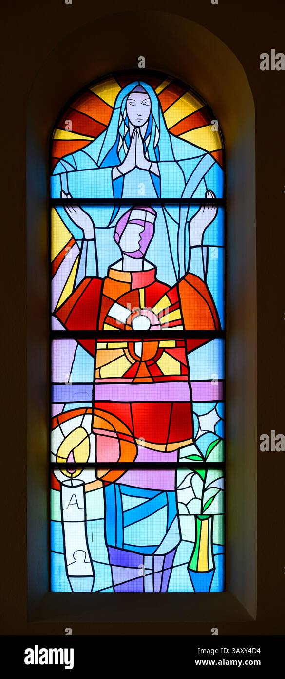A priest celebrating the Holy Mass. A stained-glass window in the St ...