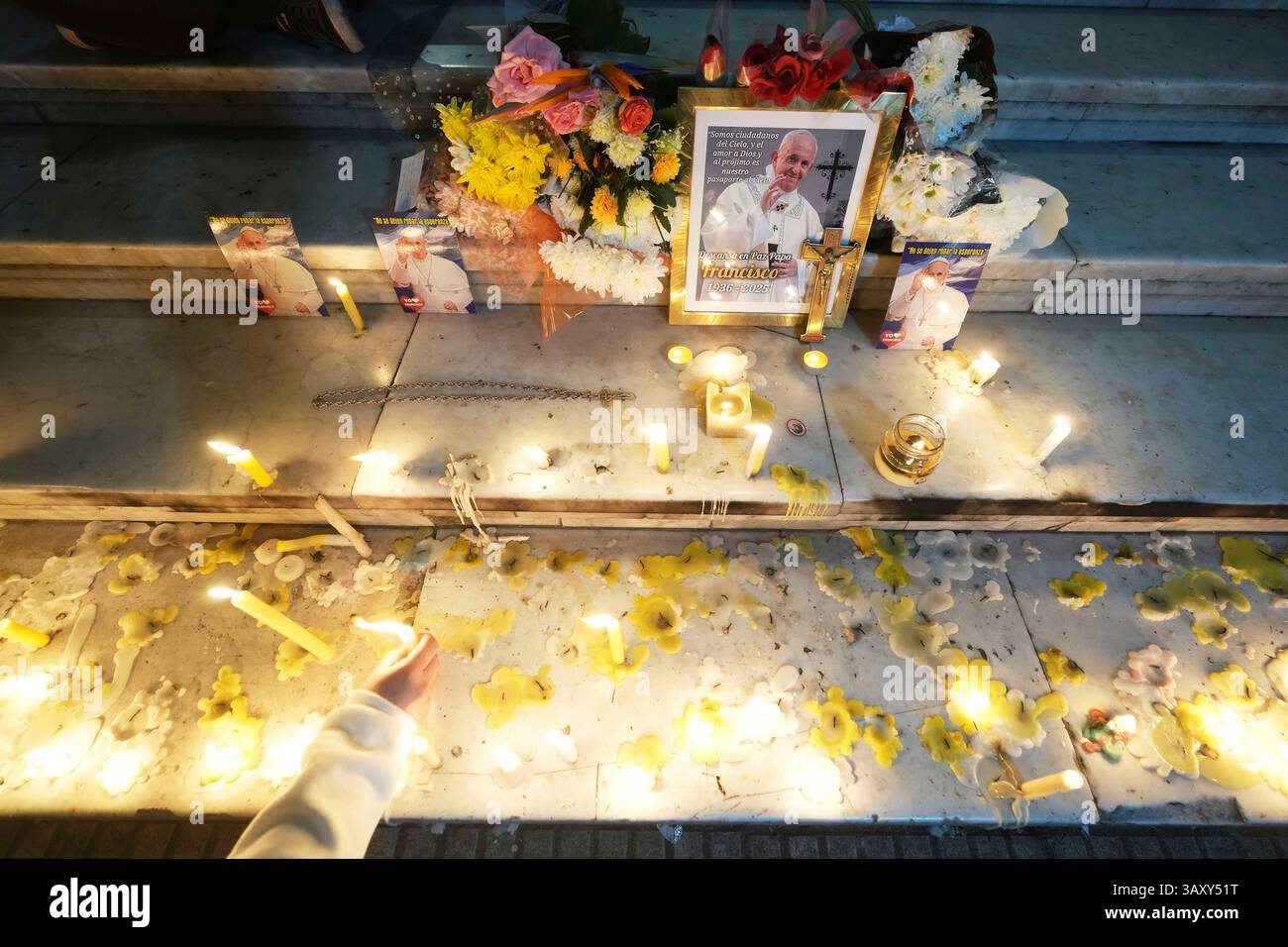 A faithful lights candles for the late Pope Francis outside the ...