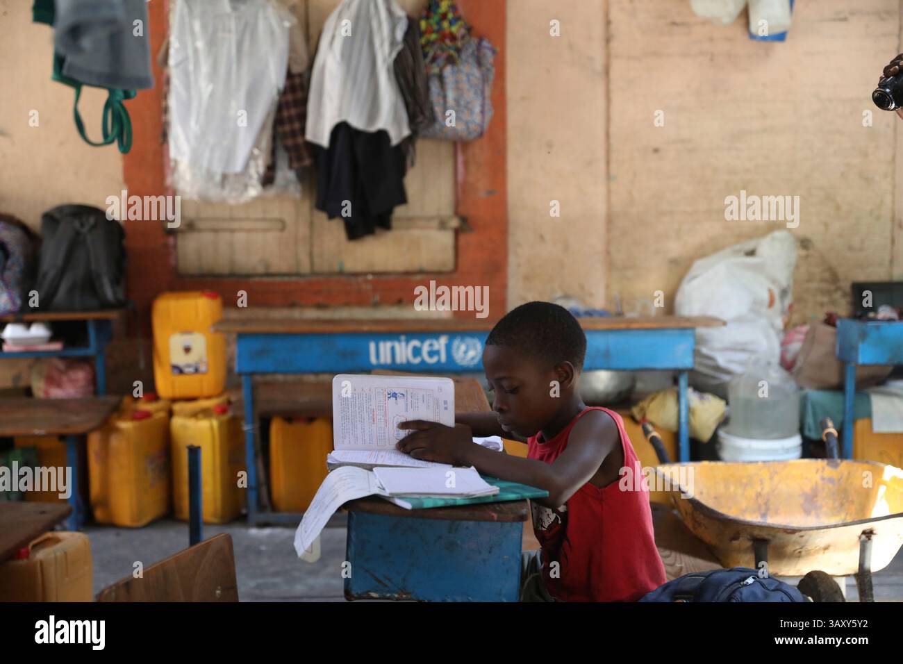 A child does homework at a school operating as a shelter for those ...
