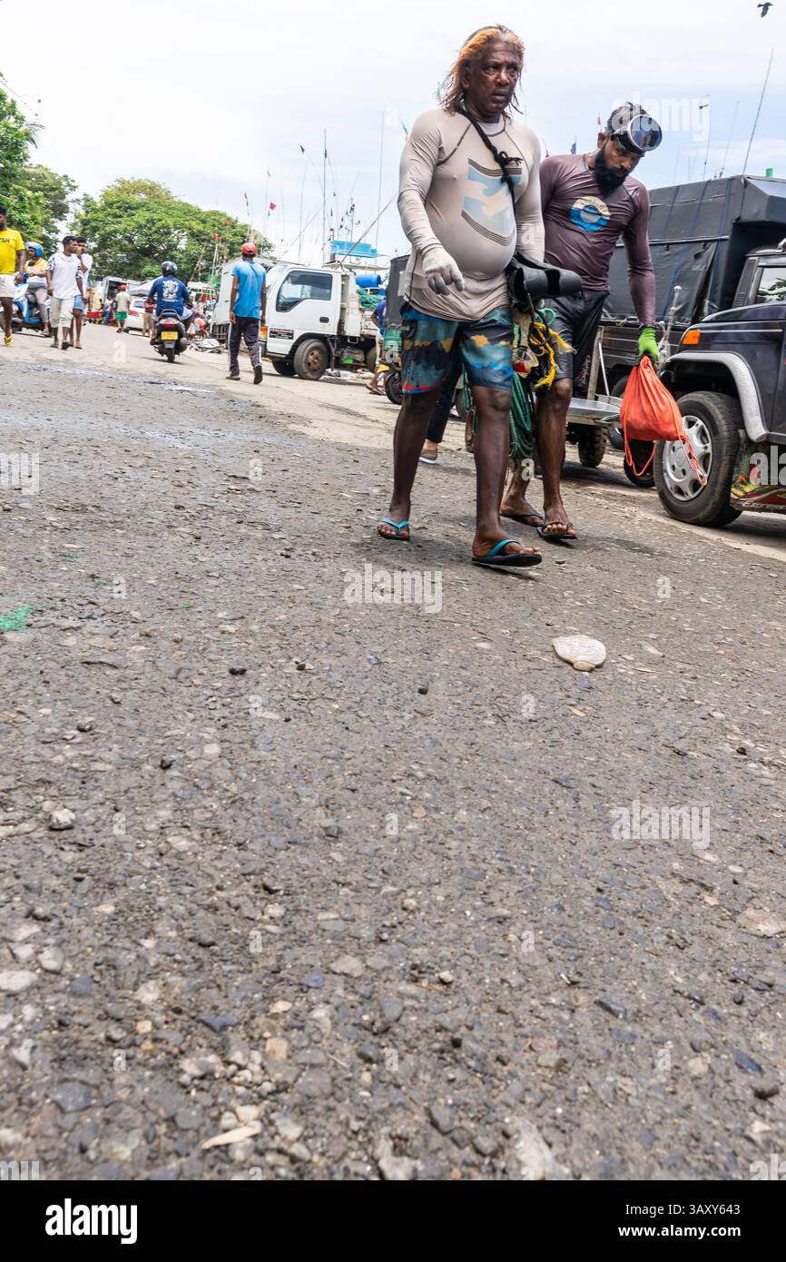 Galle Sri Lanka - September 14 2024; Two men carrying snorkeling gear ...