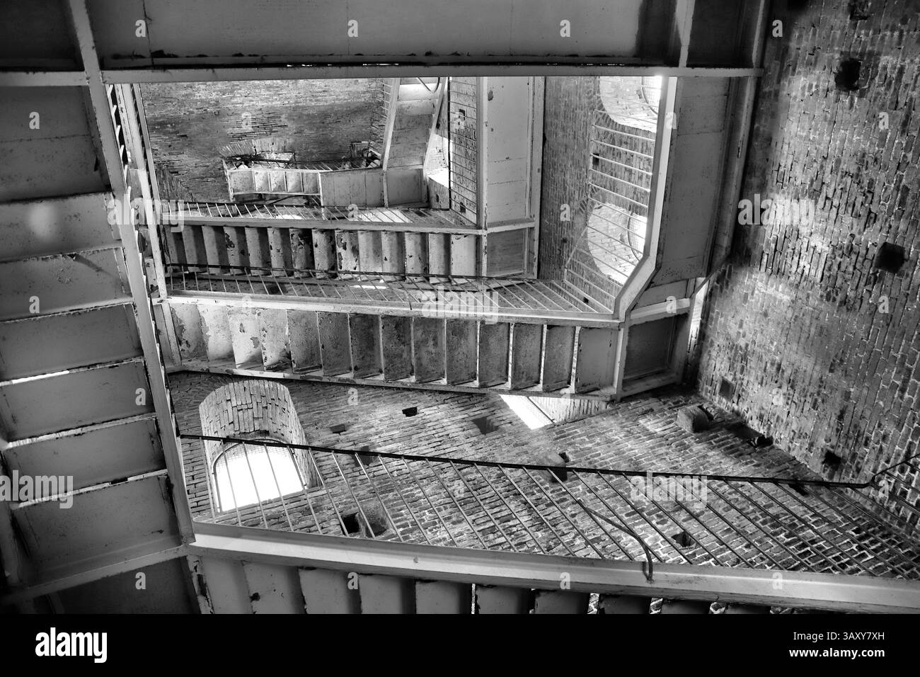Spiral staircase with stone steps winding upward inside a brick ...