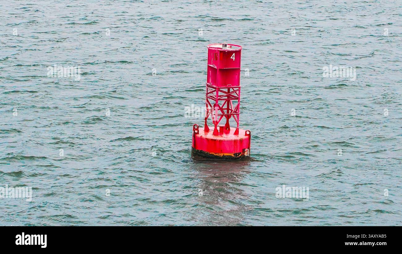 Red metal buoy, with the number 4 on one side, in slightly choppy water ...
