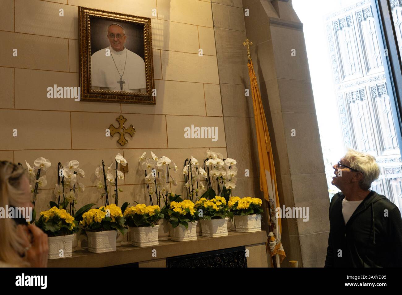 Manhattan, United States. 21st Apr, 2025. A man looks up at an image of ...