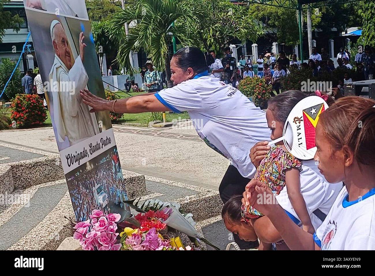 A woman touches the portrait of the late Pope Francis on banner, during ...