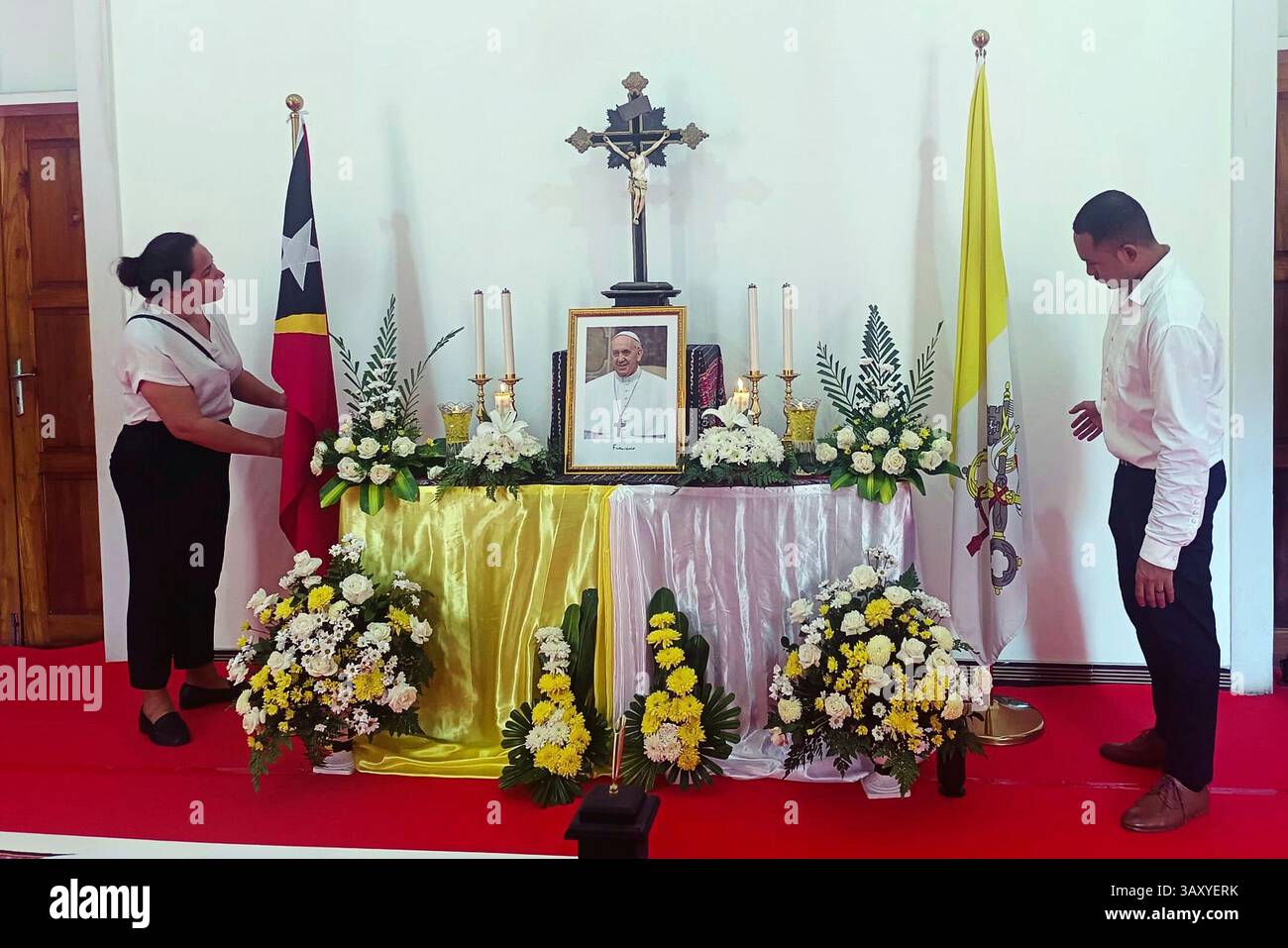 Officials prepare a condolence desk with a portrait of the late Pope ...