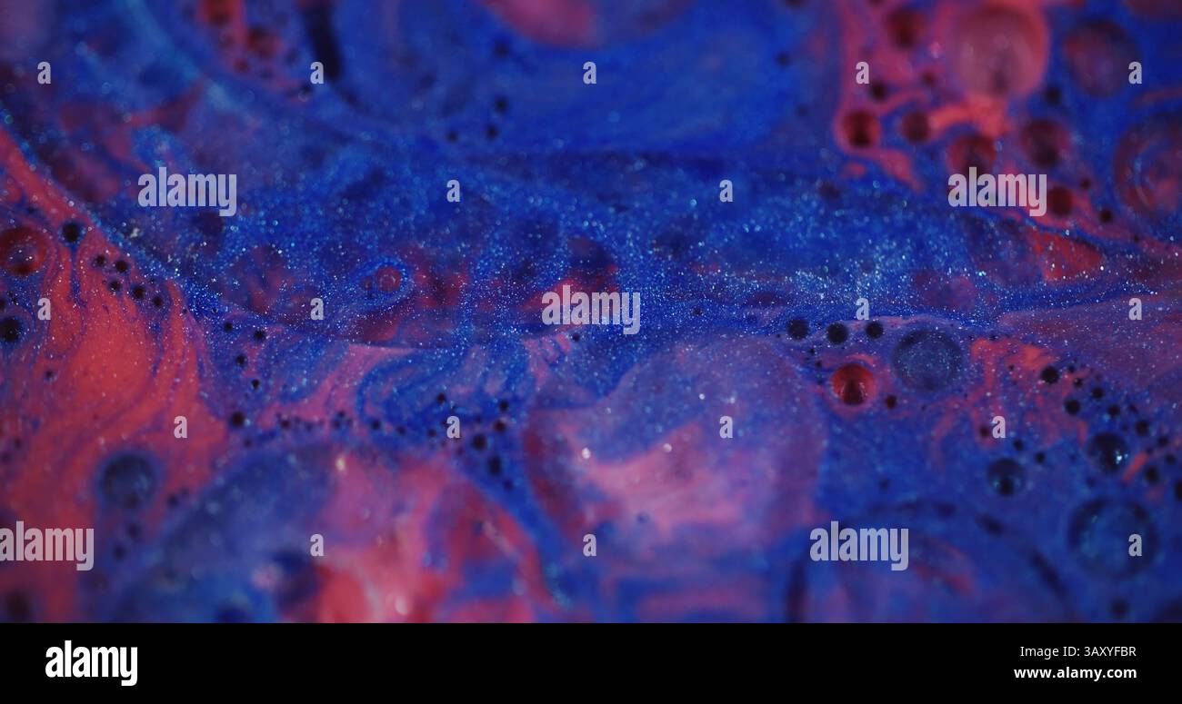 Glitter ink. Defocused fluid flow. Beautiful blue red color liquid ...