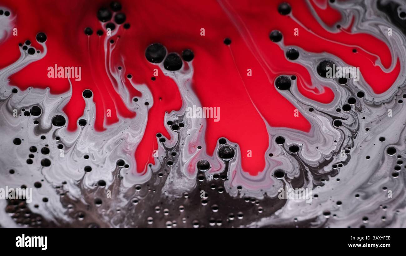 Paint spill. Bubble liquid. Defocused red silver color fluid water ...