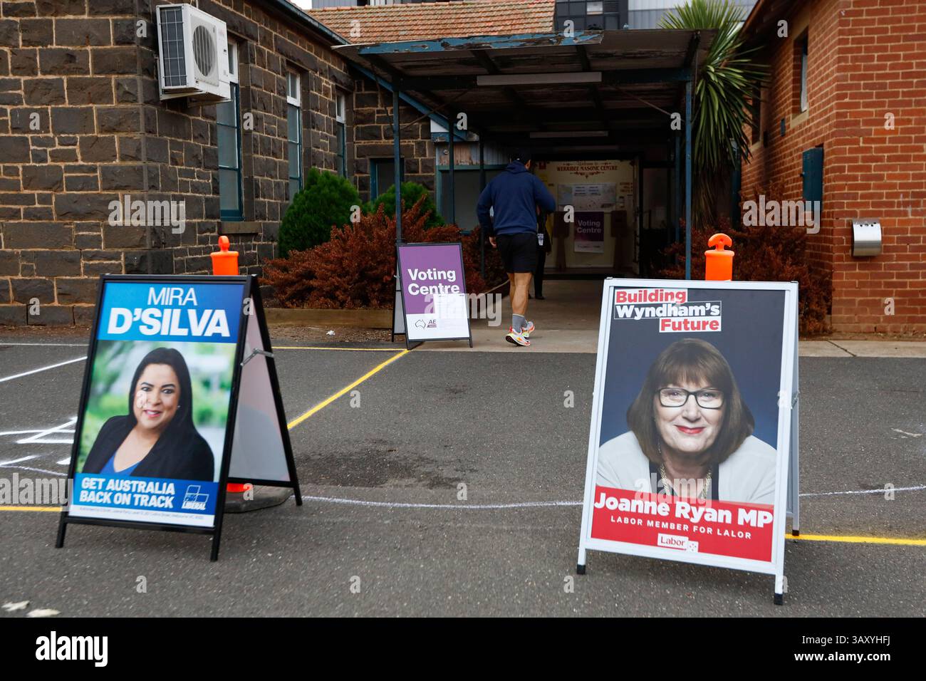 A voter walks past campaign posters inside a polling centre during ...