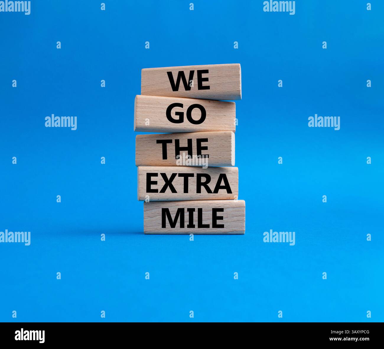 We go the extra mile symbol. Wooden blocks with words 'We go the extra ...