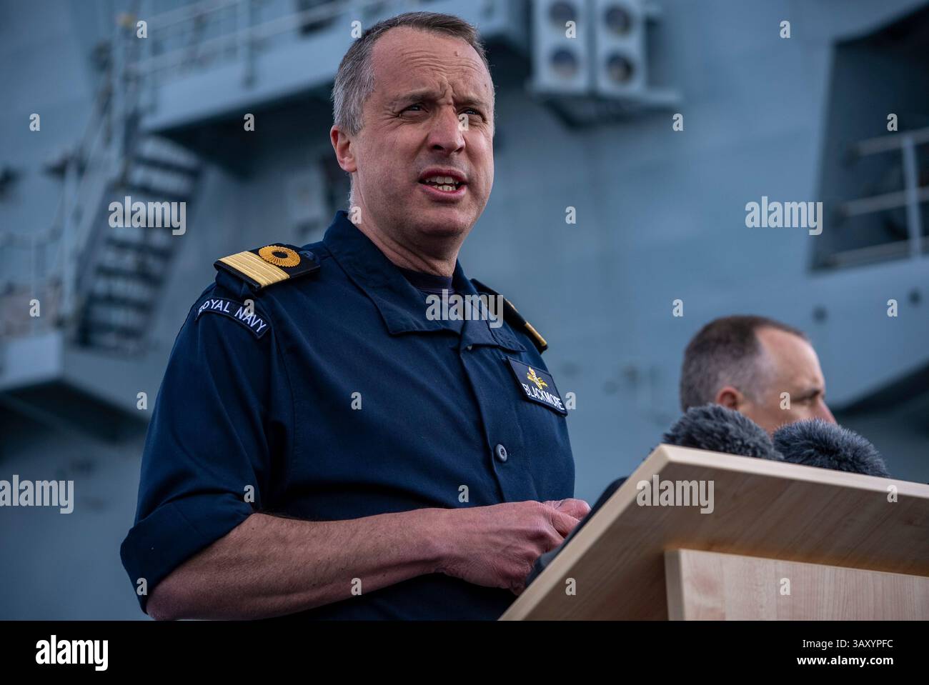 Commodore James Blackmore RN, Commander Carrier Strike Group, speaks to ...
