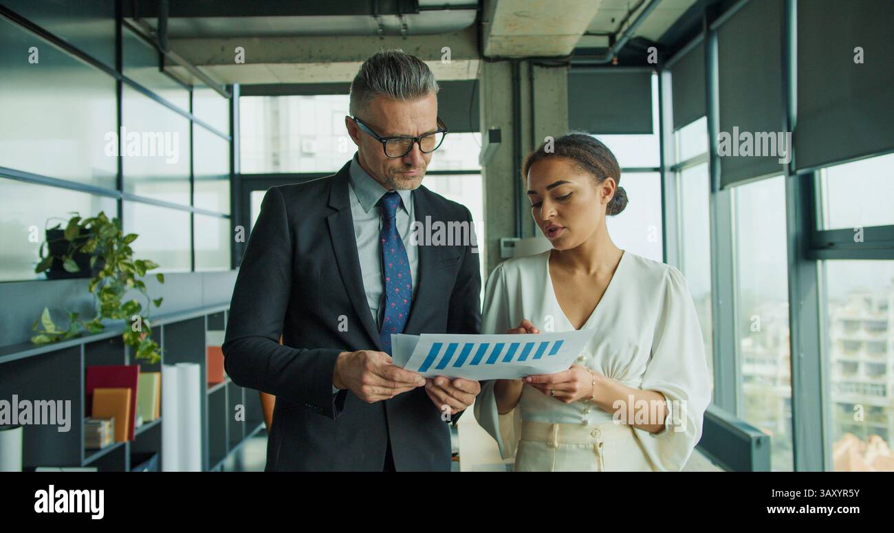Businessman and woman review a financial report Stock Photo - Alamy