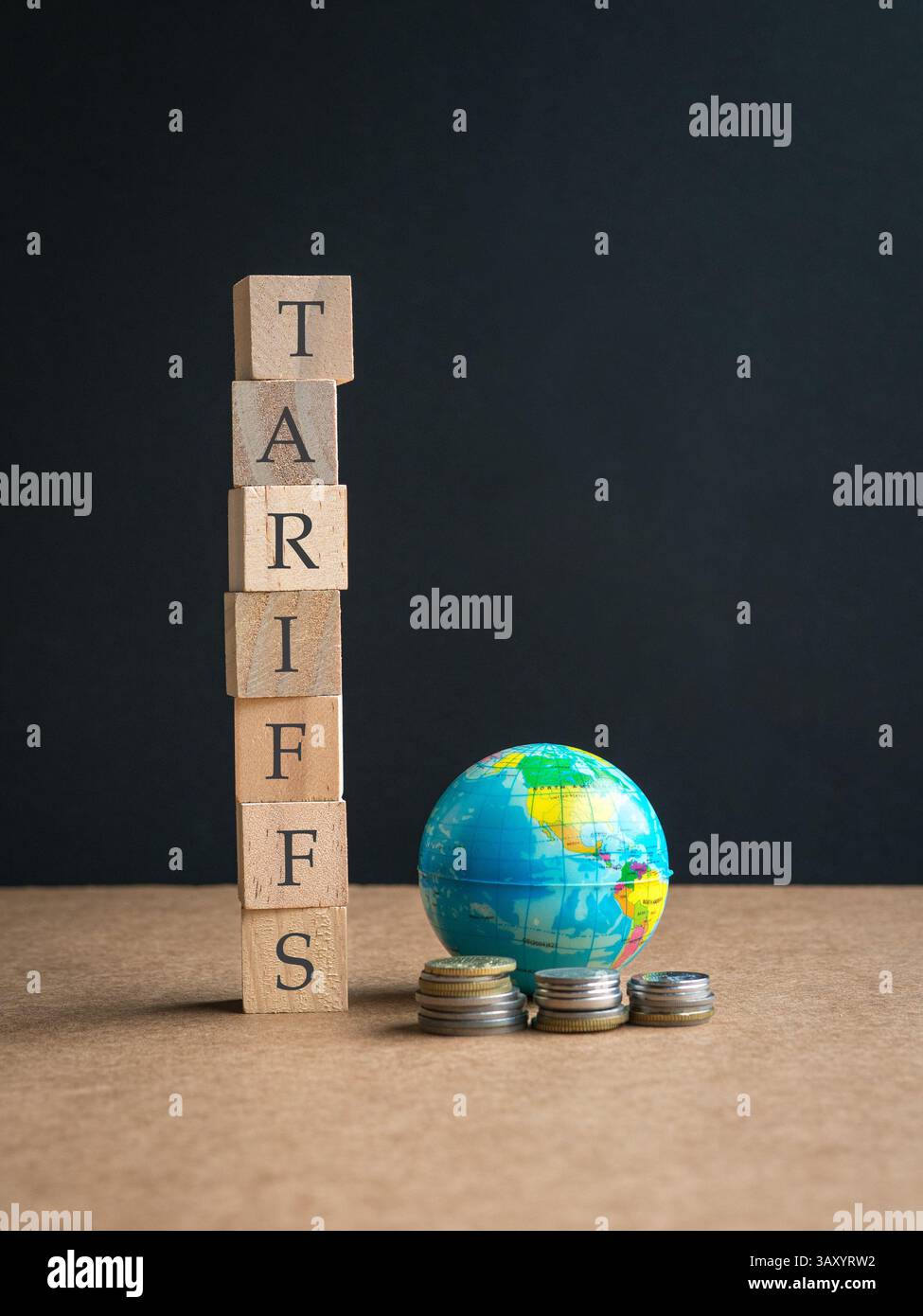 Tariffs, word on stacked square wooden blocks. Next to miniature globe ...